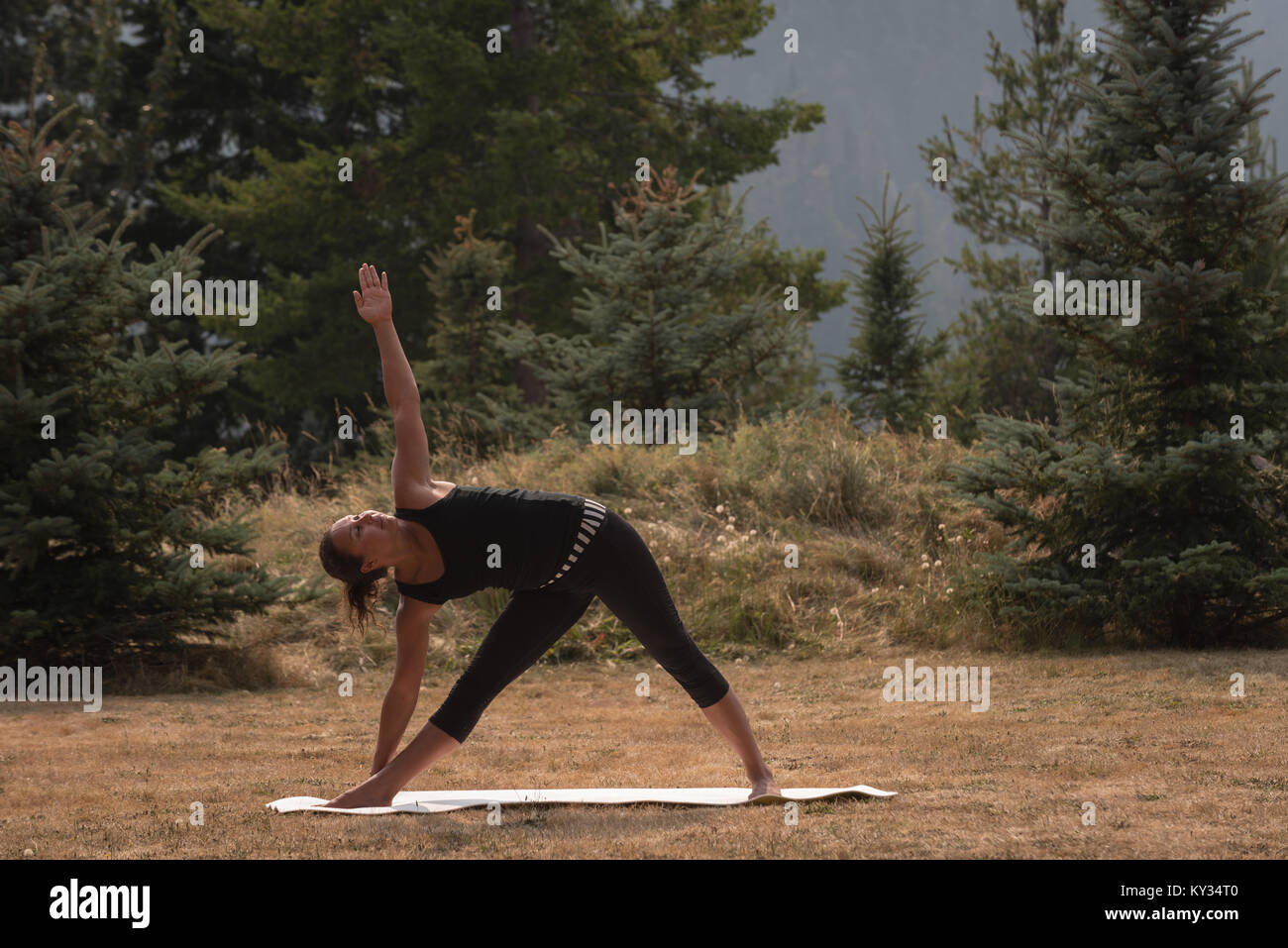 Fit woman performing stretching exercise on an open ground Stock Photo ...