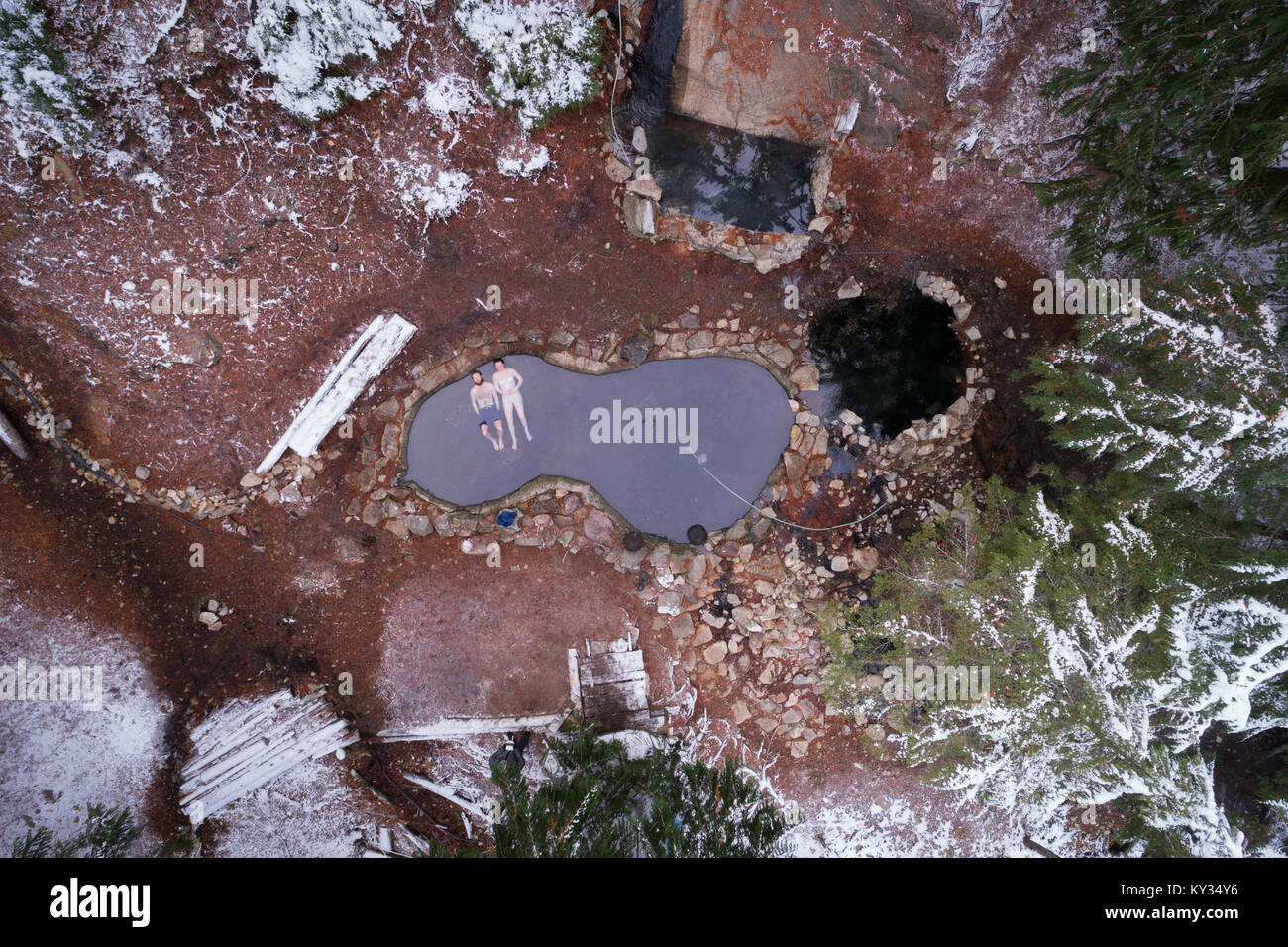 Two men lying in hot spring pool during winter Stock Photo - Alamy