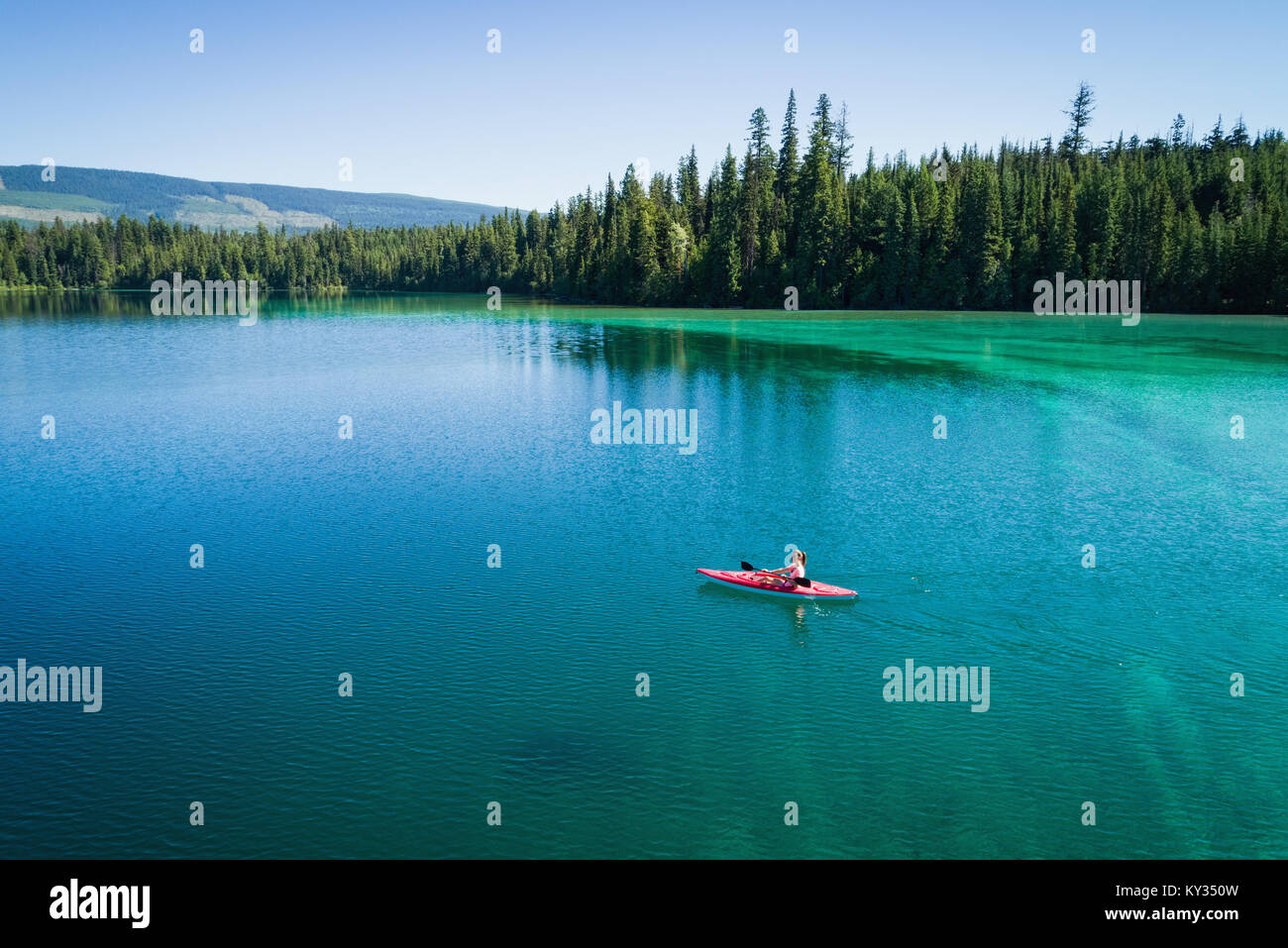 Kayaker kayaking in shallow turquoise water along the coast line Stock ...