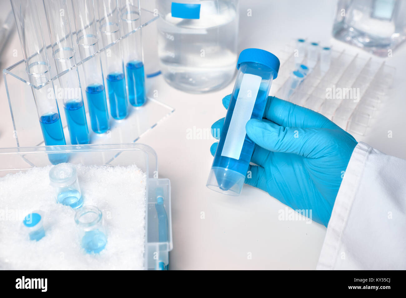 Scientific background in white and blue. Liquid sample in gloved female ...