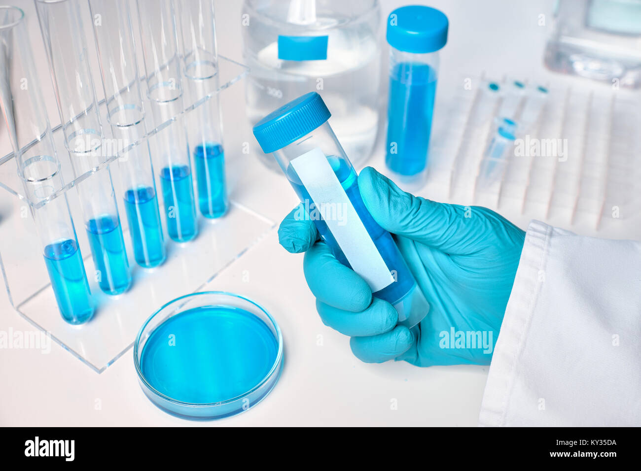 Scientific background in white and blue. Liquid sample in gloved female ...