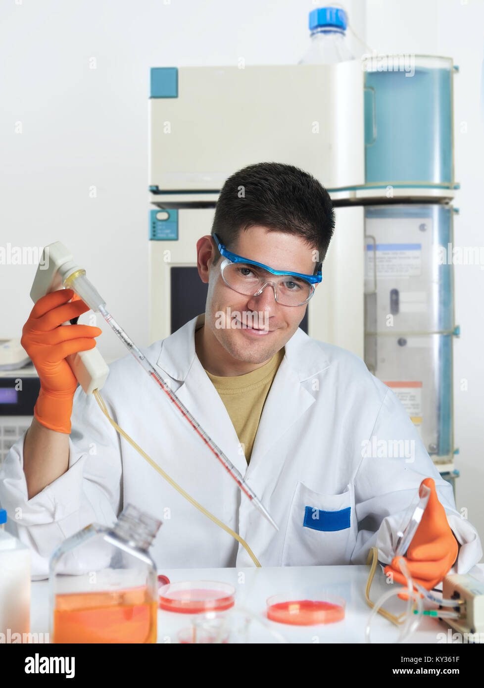 Young energetic male scientist working with cultured cells smiles at ...