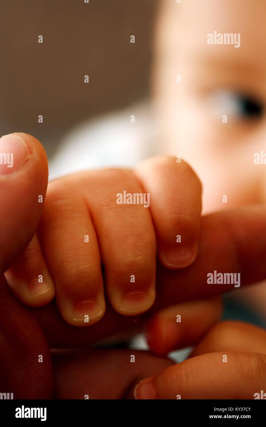 young baby holding older hand- focus on child hand Stock Photo - Alamy