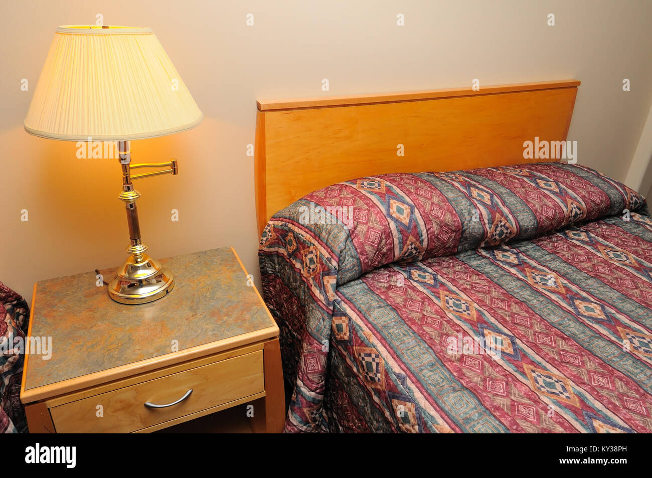 Clean and tidy bed with lamp on side table Stock Photo - Alamy