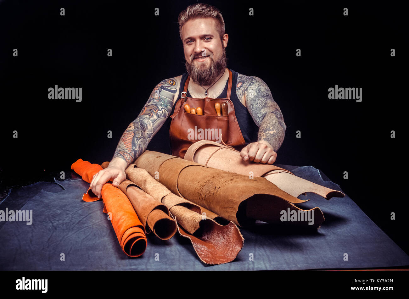 Man working with leather manufactures new product made of leather at ...