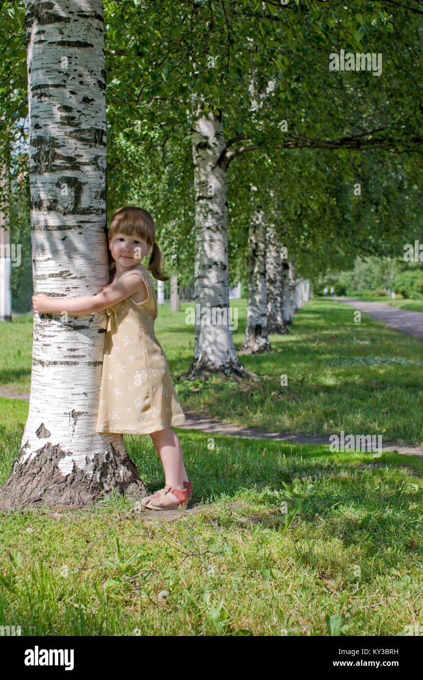 Child holding birch tree with love in the woods looking at you Stock ...