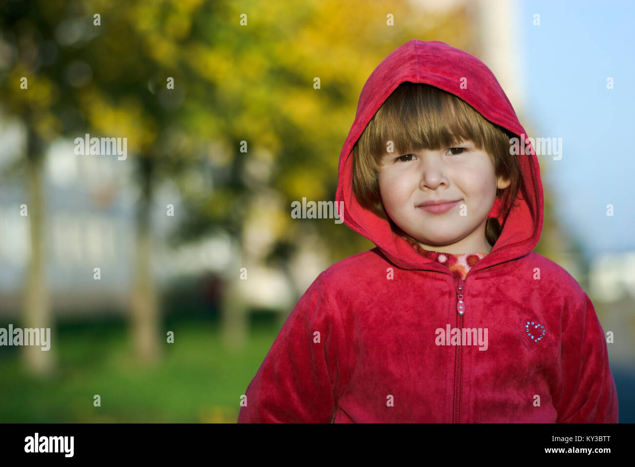 Serious kid standing outside in sunset lights Stock Photo - Alamy
