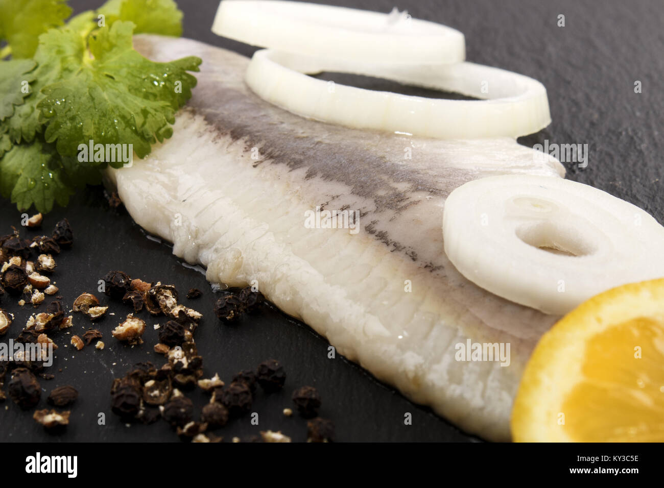 fresh herring fillet with slice lemon, parsley and crushed pepper on ...