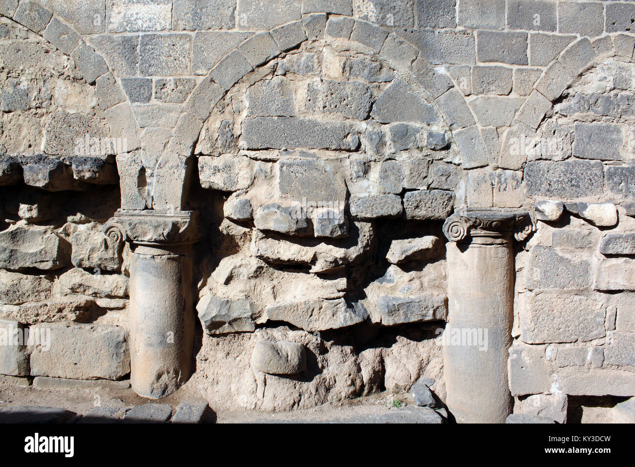 Arc, stone wall and columns on the street of Bosra in Syria Stock Photo ...
