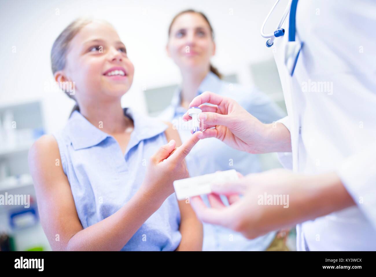 Doctor giving young girl a finger prick test Stock Photo - Alamy
