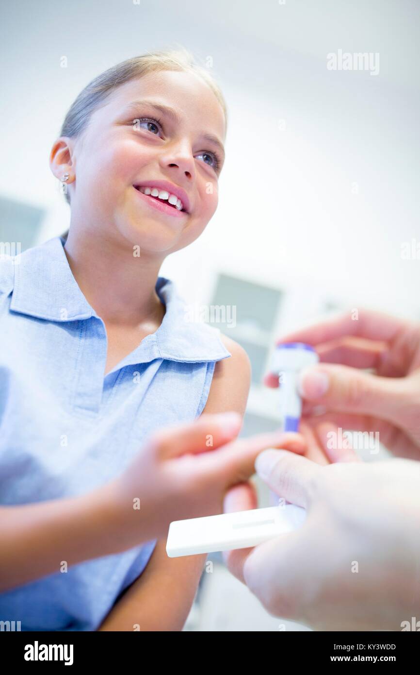 Doctor giving young girl a finger prick test Stock Photo - Alamy