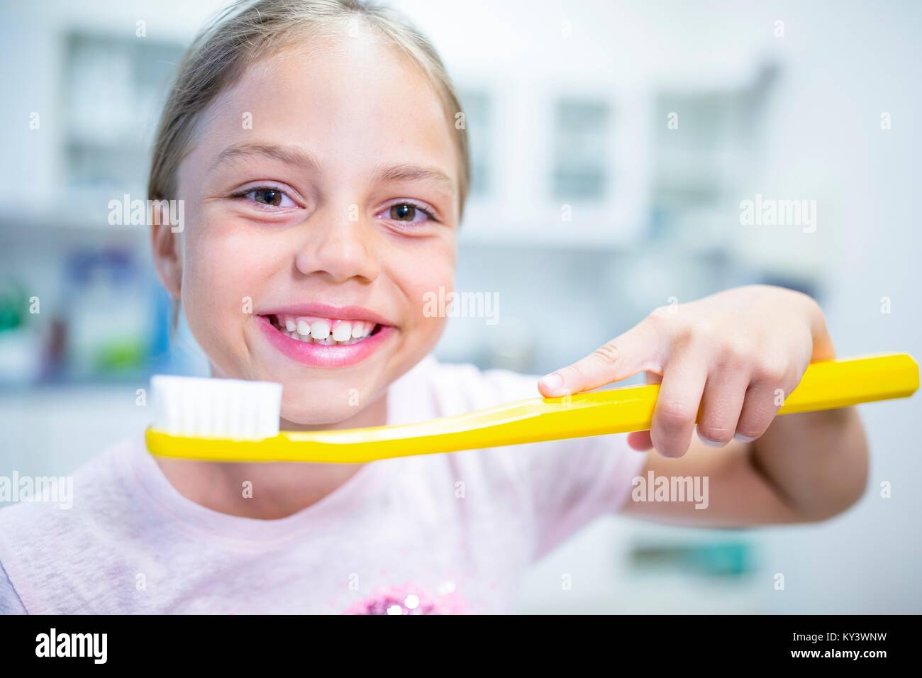 Girl holding oversized toothbrush Stock Photo - Alamy
