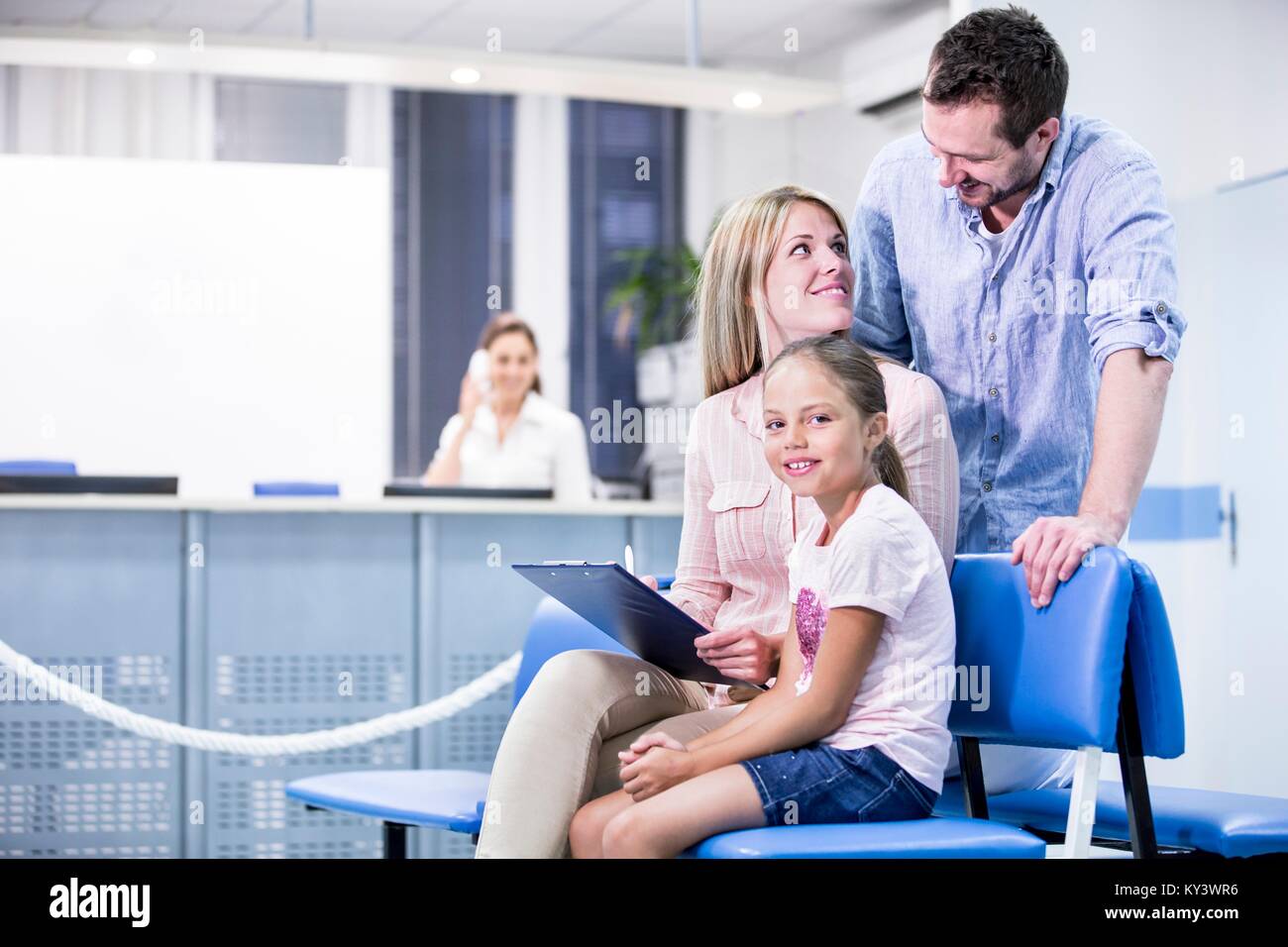 Family in medical waiting room, girl smiling towards camera Stock Photo ...