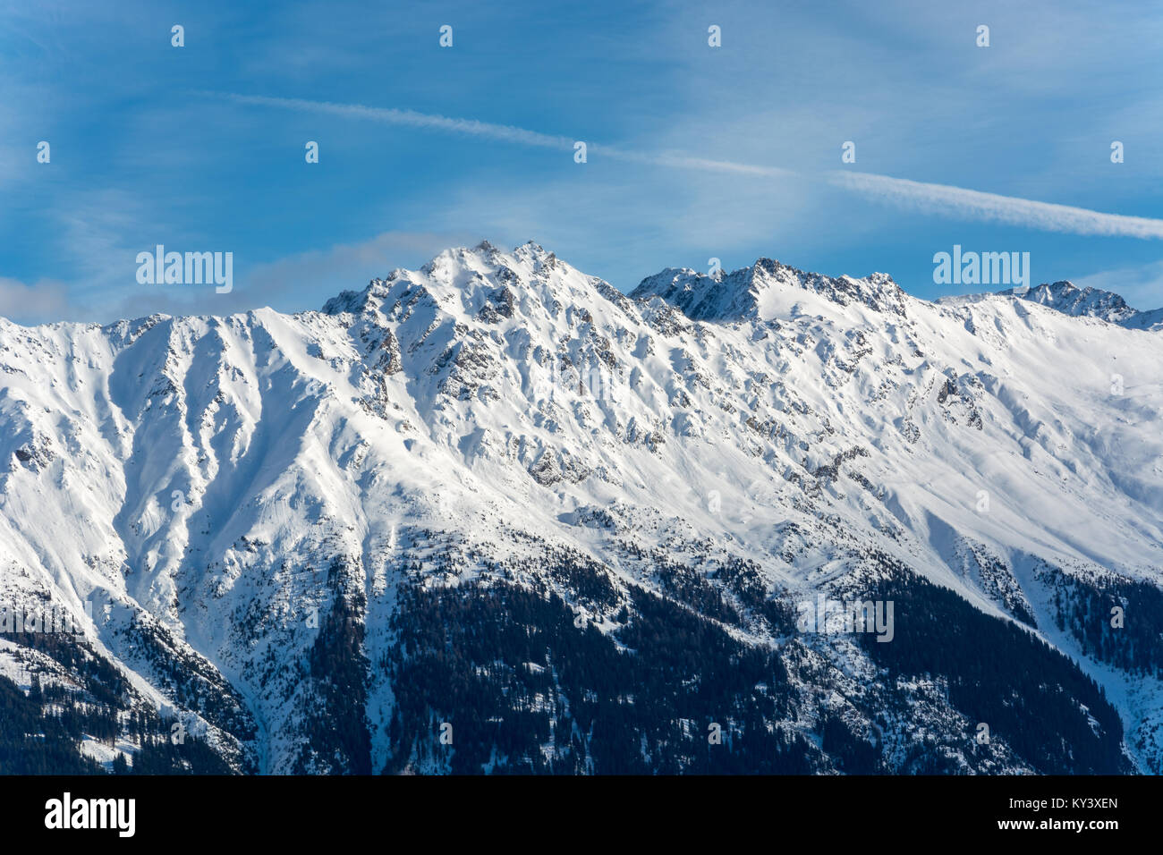 Snowy mountains in the alps with sunshine and blue sky Stock Photo - Alamy