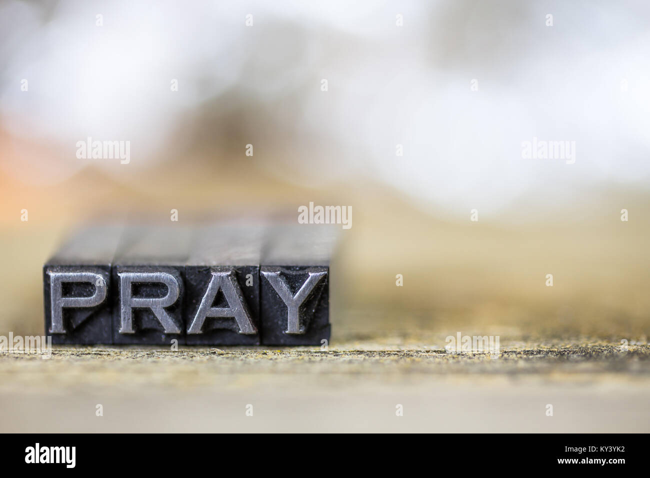 The word PRAY concept written in vintage retro metal letterpress type ...