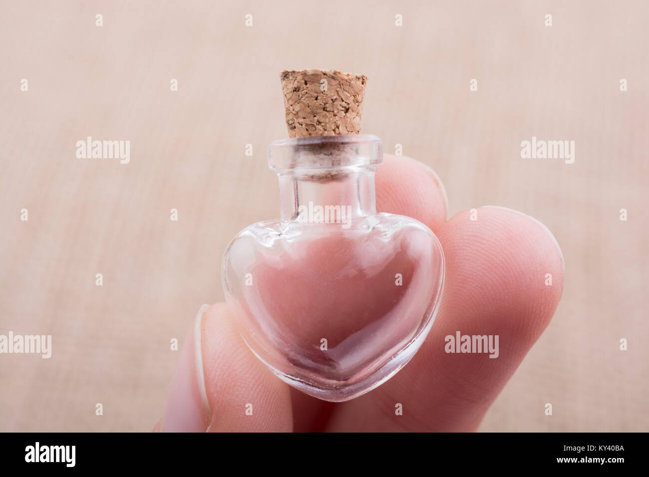 Heart shaped glass bottle is held in hand Stock Photo - Alamy