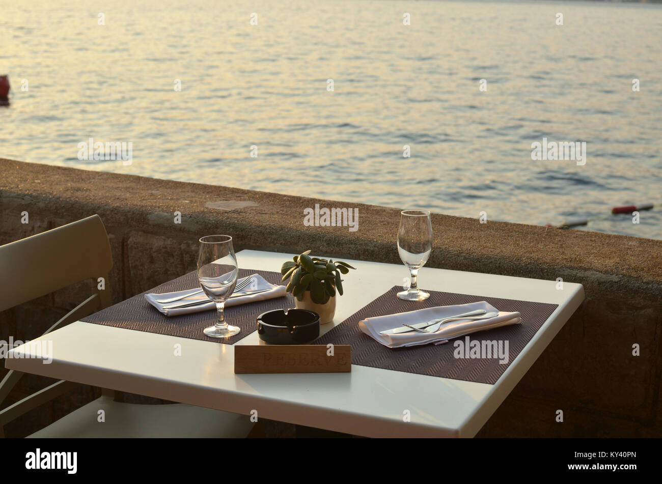 Set table of a restaurant with a sea view Stock Photo - Alamy
