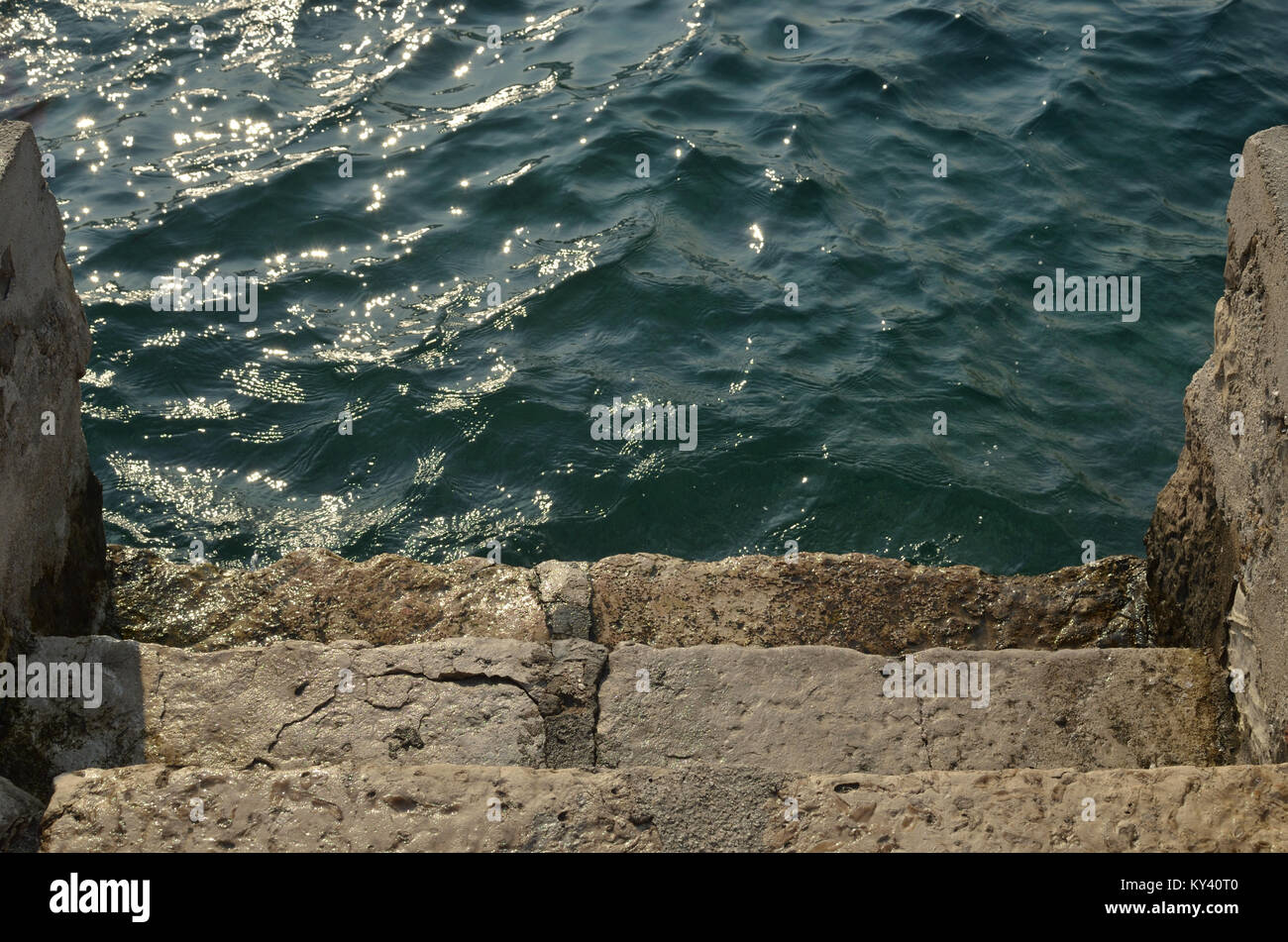 Stone stairs going to the sea and green and blue sea surface of the ...