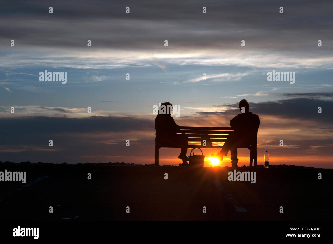 Couple enjoying the evening sunset on Aberaeron seafront, Ceredigion ...