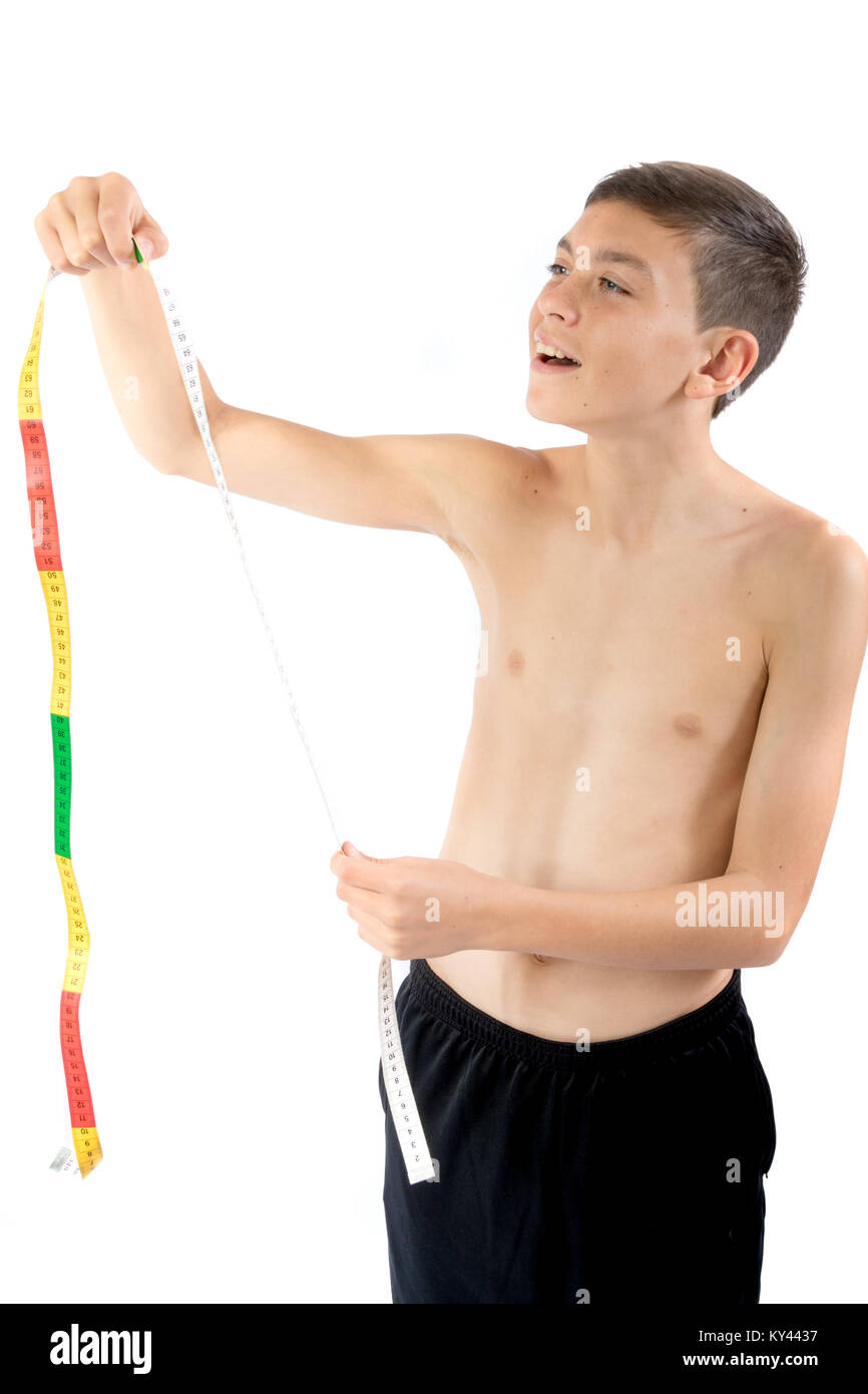 Teenage boy looking happy at a tape measure Stock Photo - Alamy