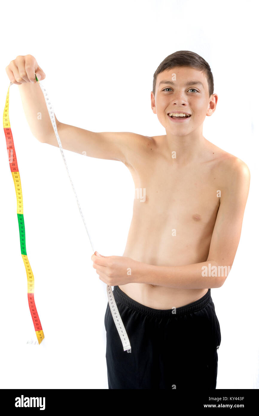 Teenage boy looking happy at a tape measure Stock Photo - Alamy