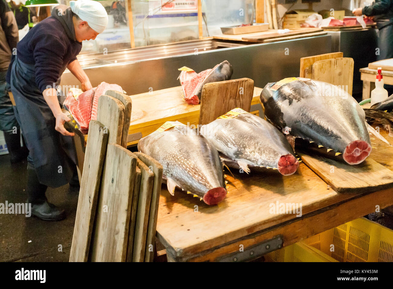 Tokyo, Japan. Early morning at Tsukiji Fish Market. Vendor cutting tuna ...