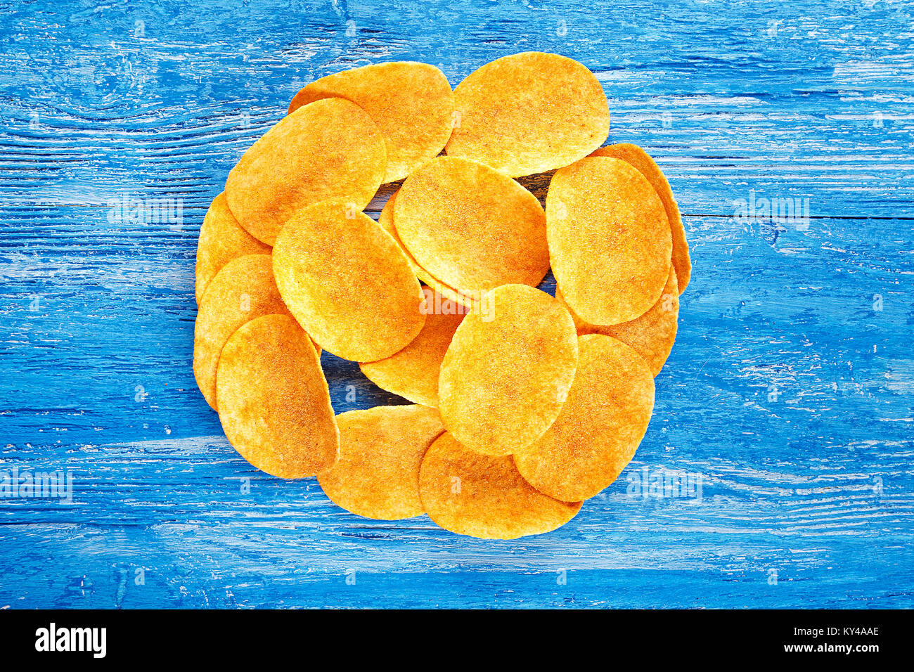 potato chips on a blue wooden background, cold snack, unhealthy eating ...