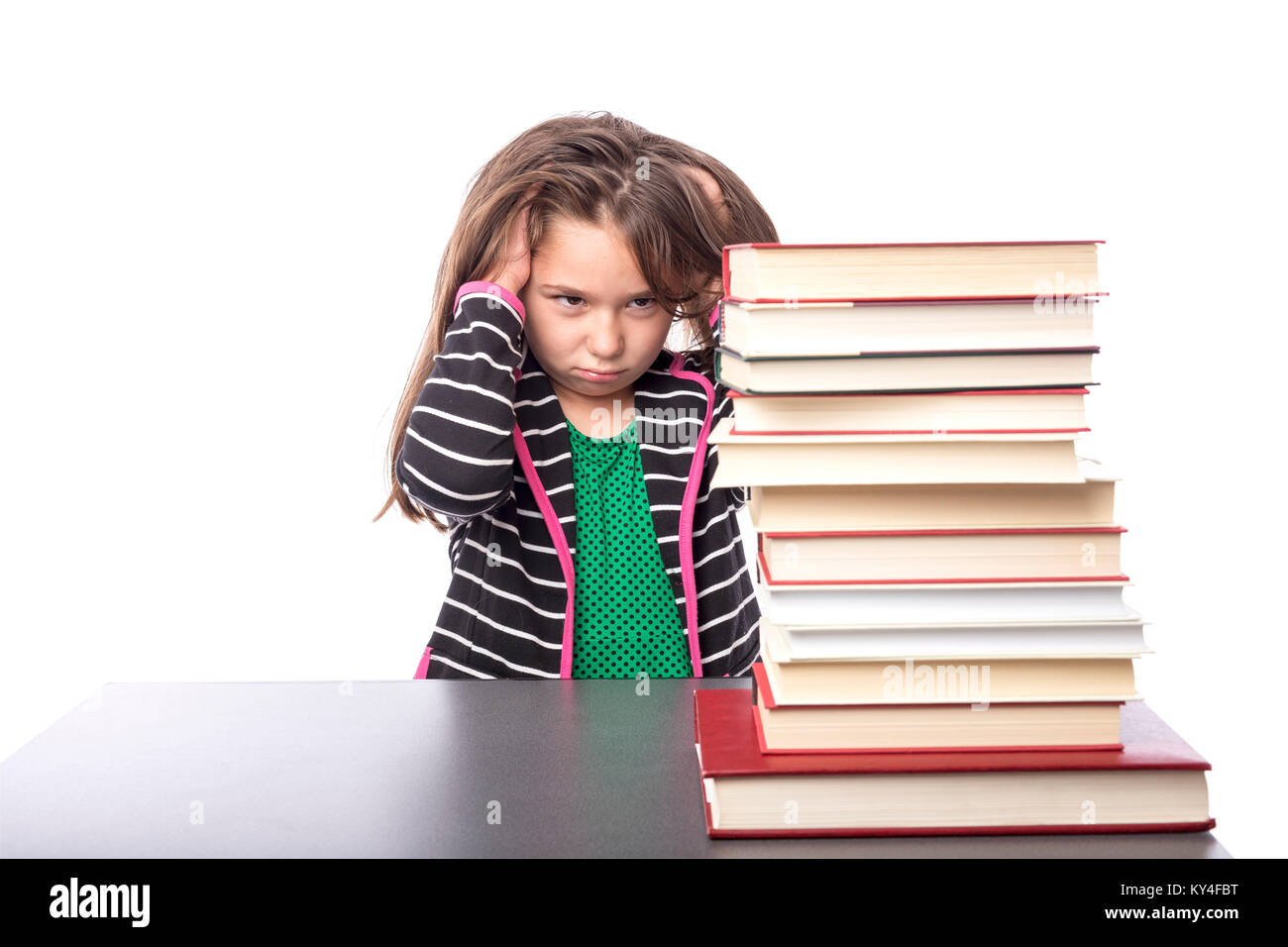 Studio shot of hopeless student with hands on head looking at a stack ...