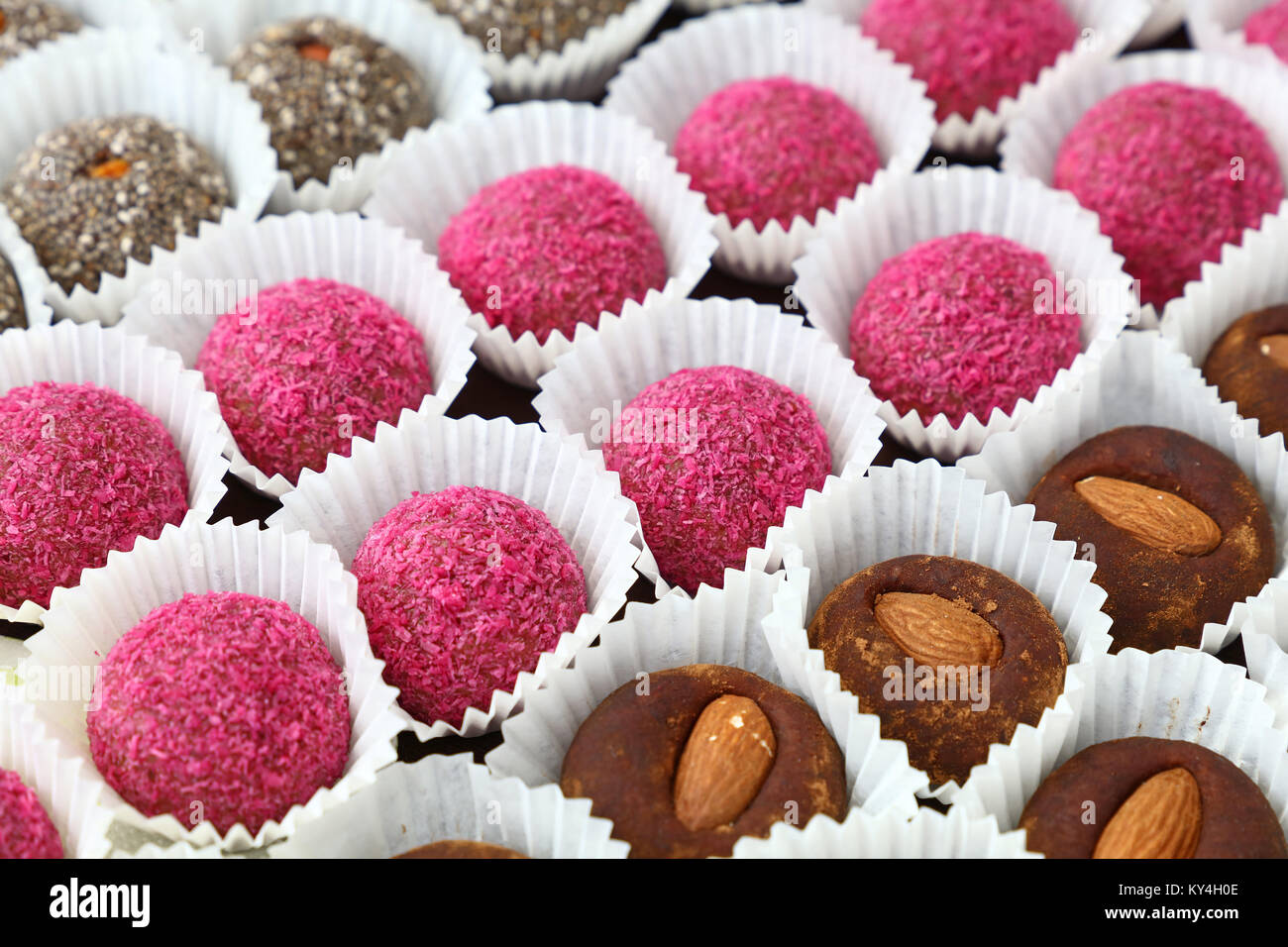 Close up selection of assorted sweet candy cookies in white paper cups ...