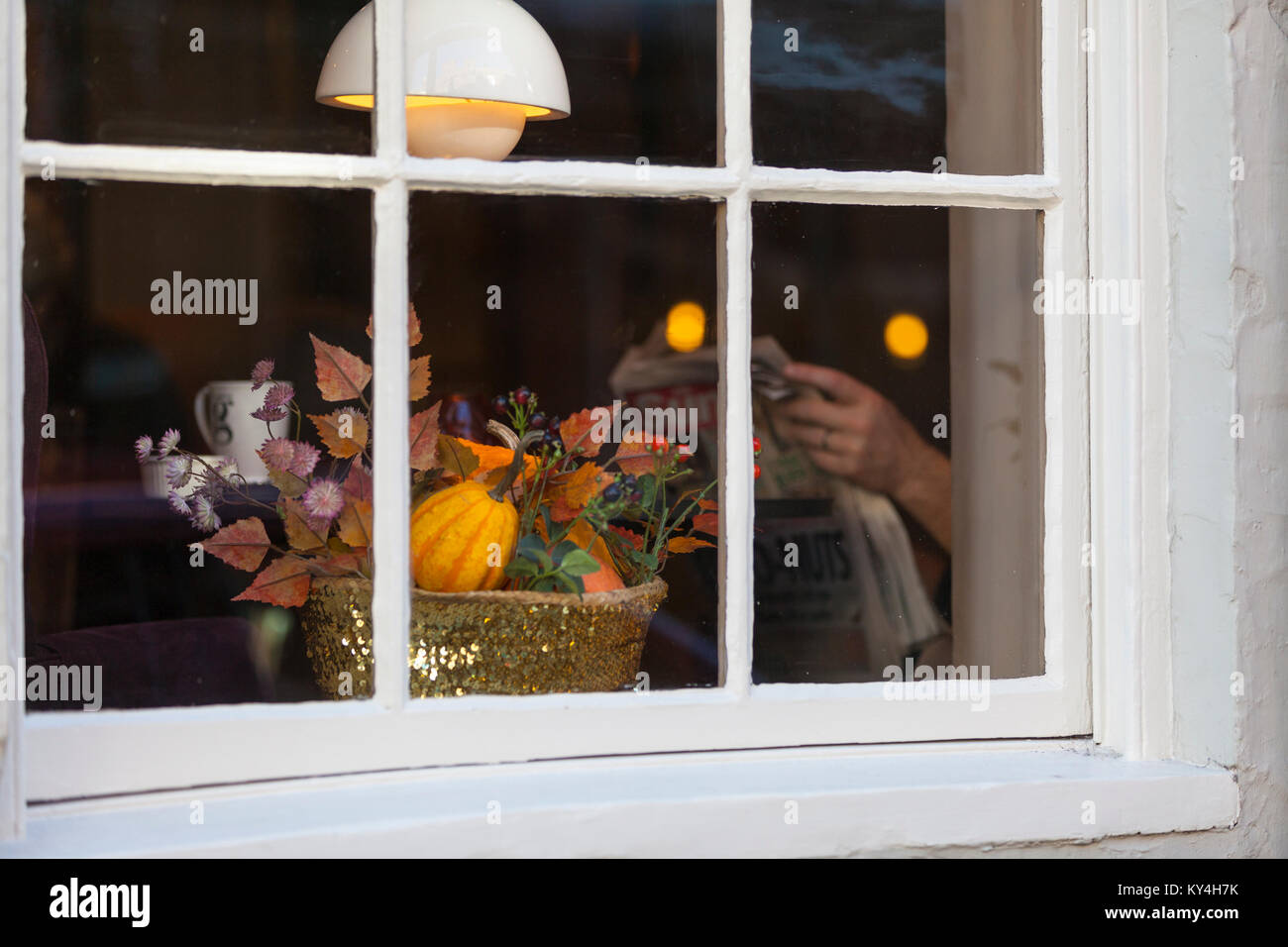 A golden basket full of artificial flowers sitting in a victorian ...