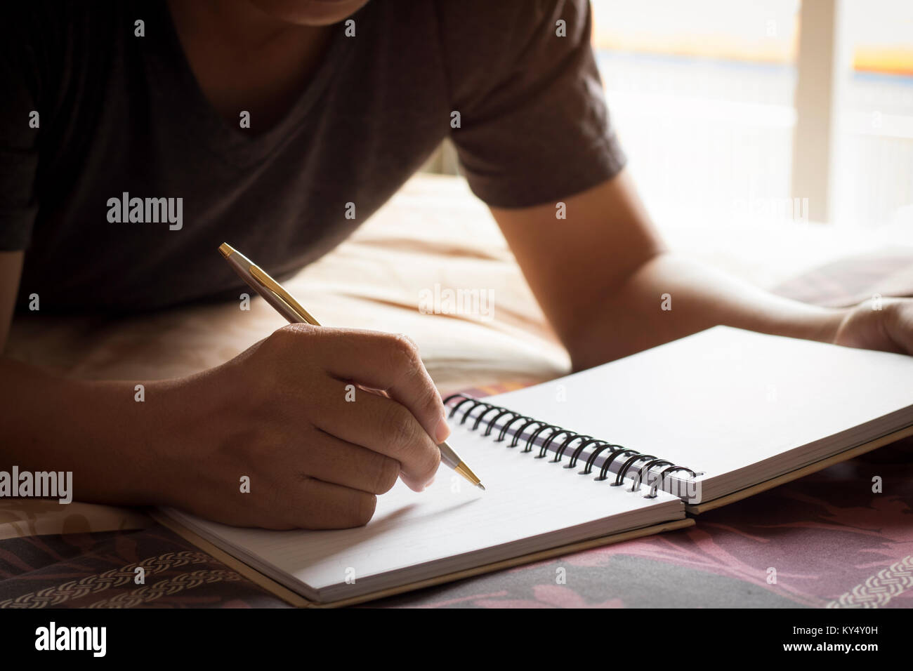 writing on notebook in bed Stock Photo - Alamy