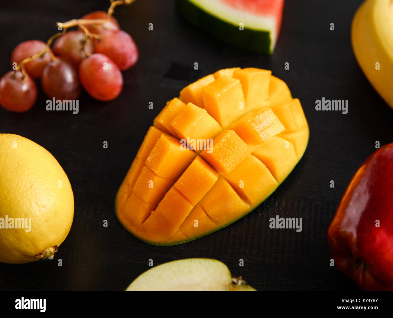 close up portrait of healthy sliced yellow mango on black background ...