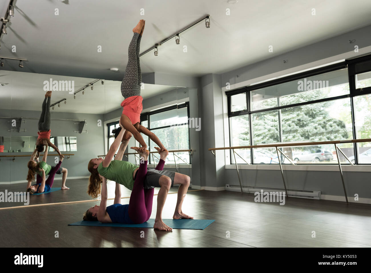 Group of fit people practicing acroyoga Stock Photo - Alamy