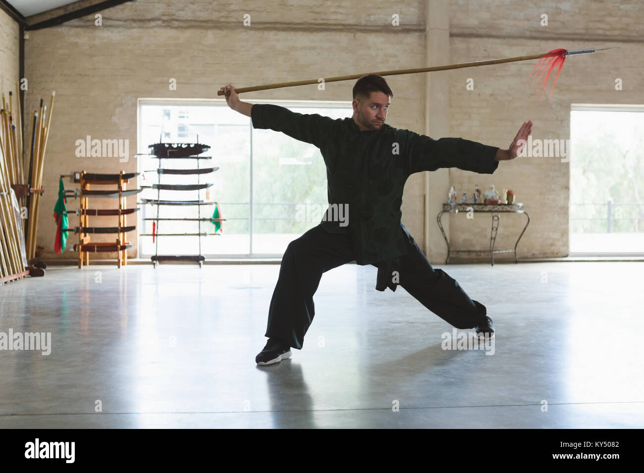 Kung fu fighter practicing with long pole Stock Photo - Alamy