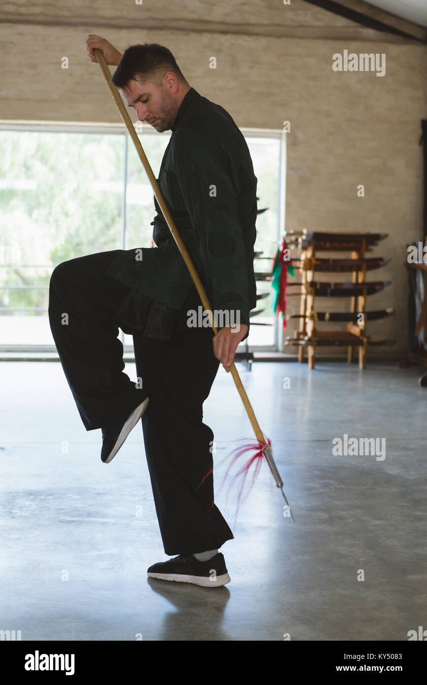 Kung fu fighter practicing with long pole Stock Photo - Alamy