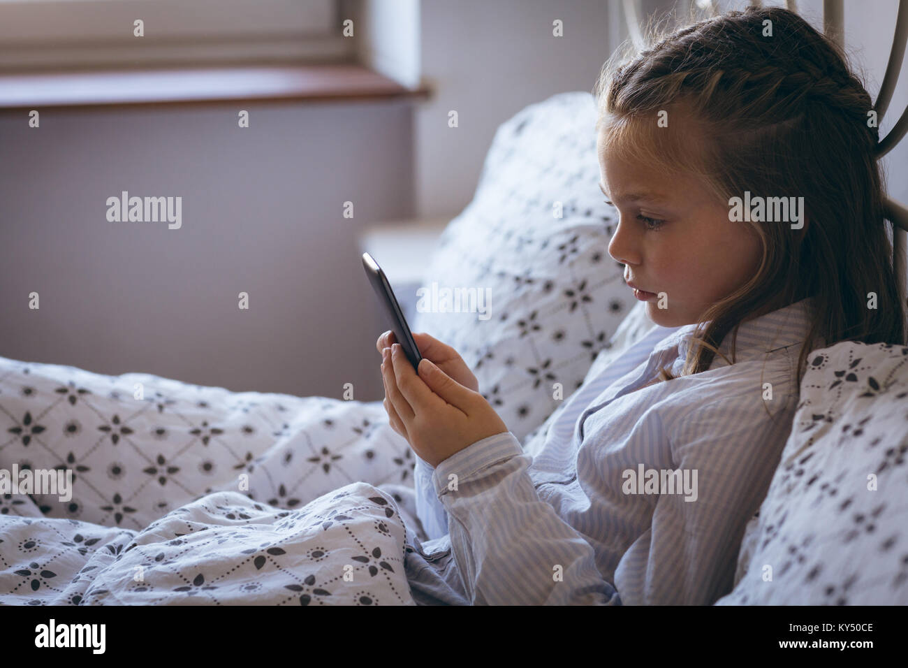 Girl using mobile phone on bed Stock Photo - Alamy