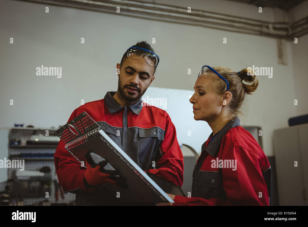 Two worker discussing over machine board Stock Photo - Alamy