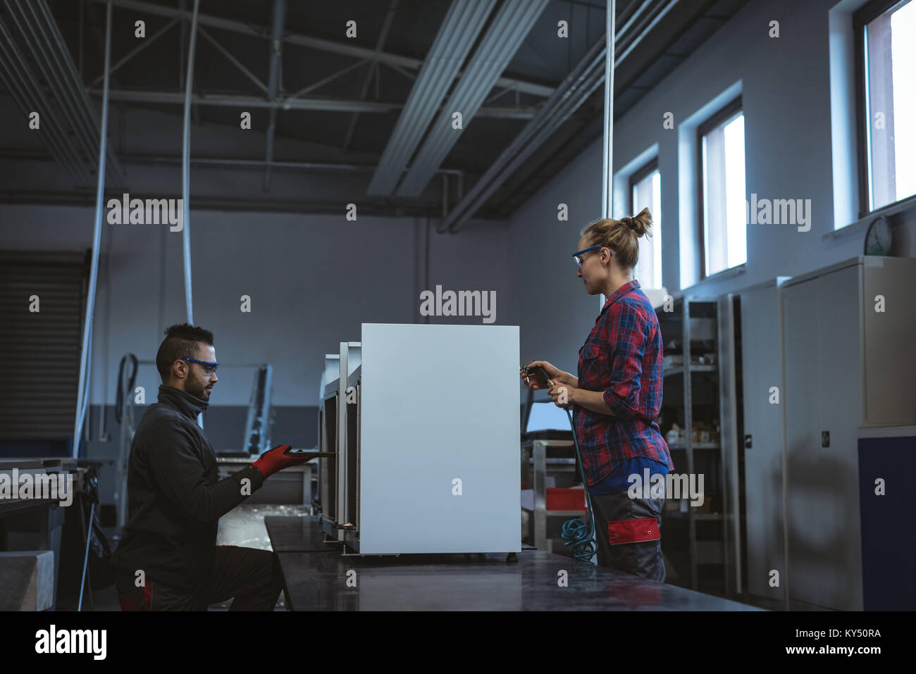 Two workers checking machine parts Stock Photo - Alamy