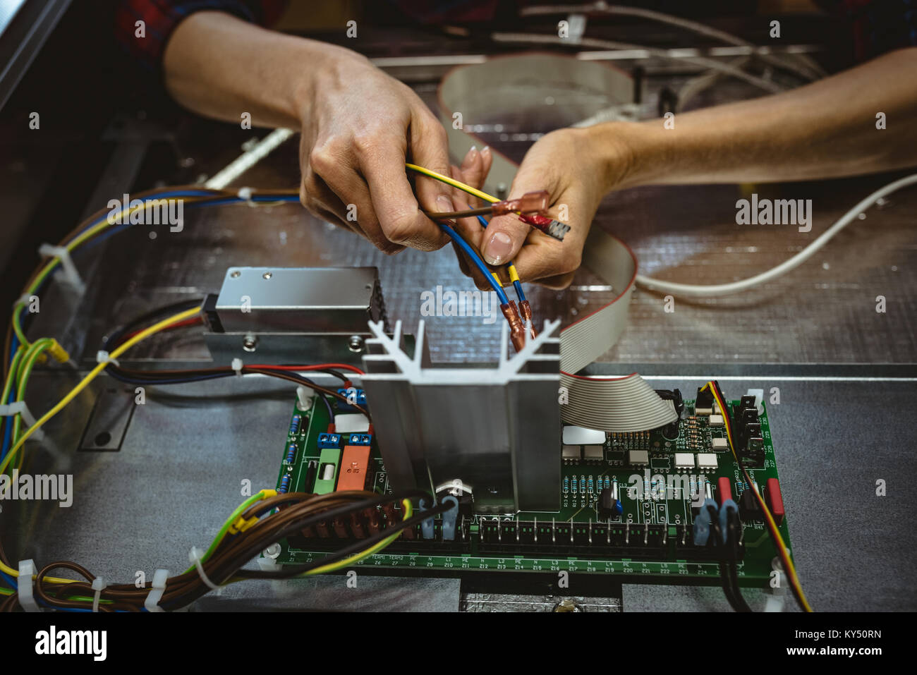 Female worker attaching a wire on circuit board Stock Photo - Alamy