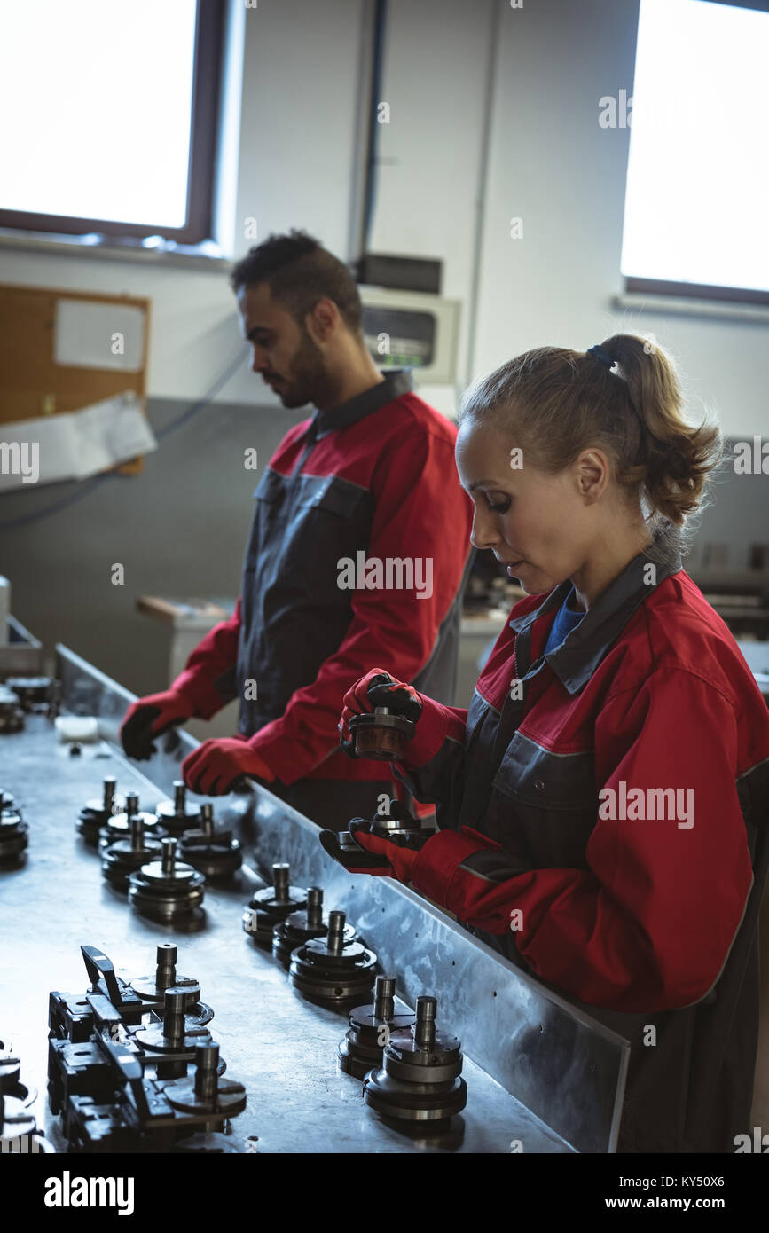 Two workers checking machine parts Stock Photo - Alamy