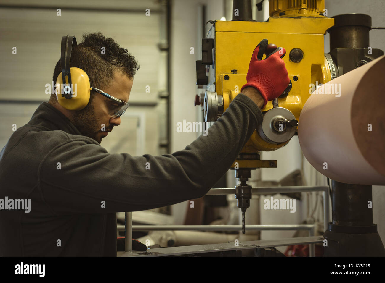 Male worker operating a machine Stock Photo - Alamy