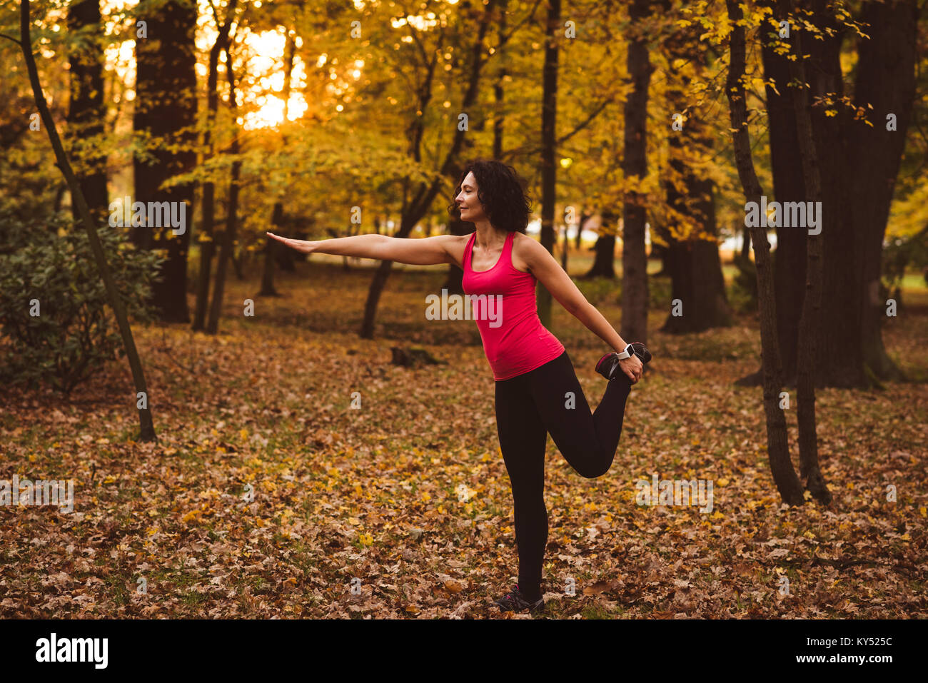 Woman performing stretching exercise in forest Stock Photo - Alamy