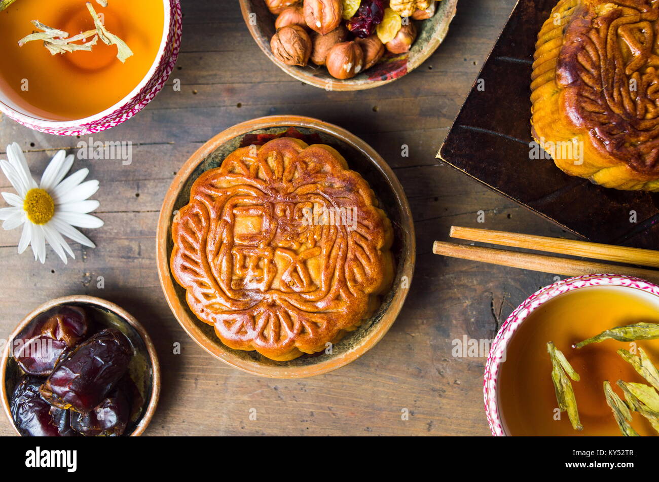 Chinese mooncake with tea,hazelnut, and arabic date served on wooden ...