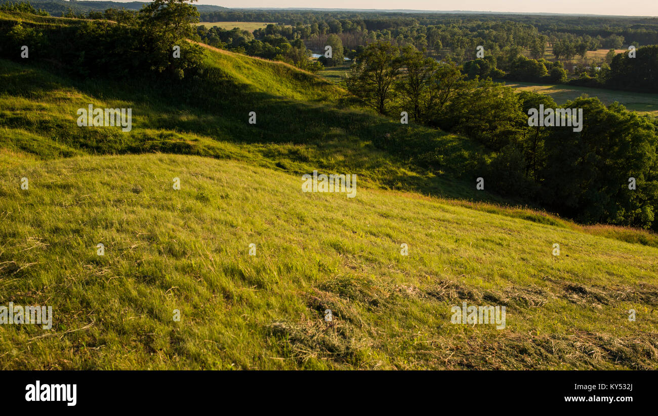 mowed grass in a hilly area. Spring season. Rural landscape. Sunset ...