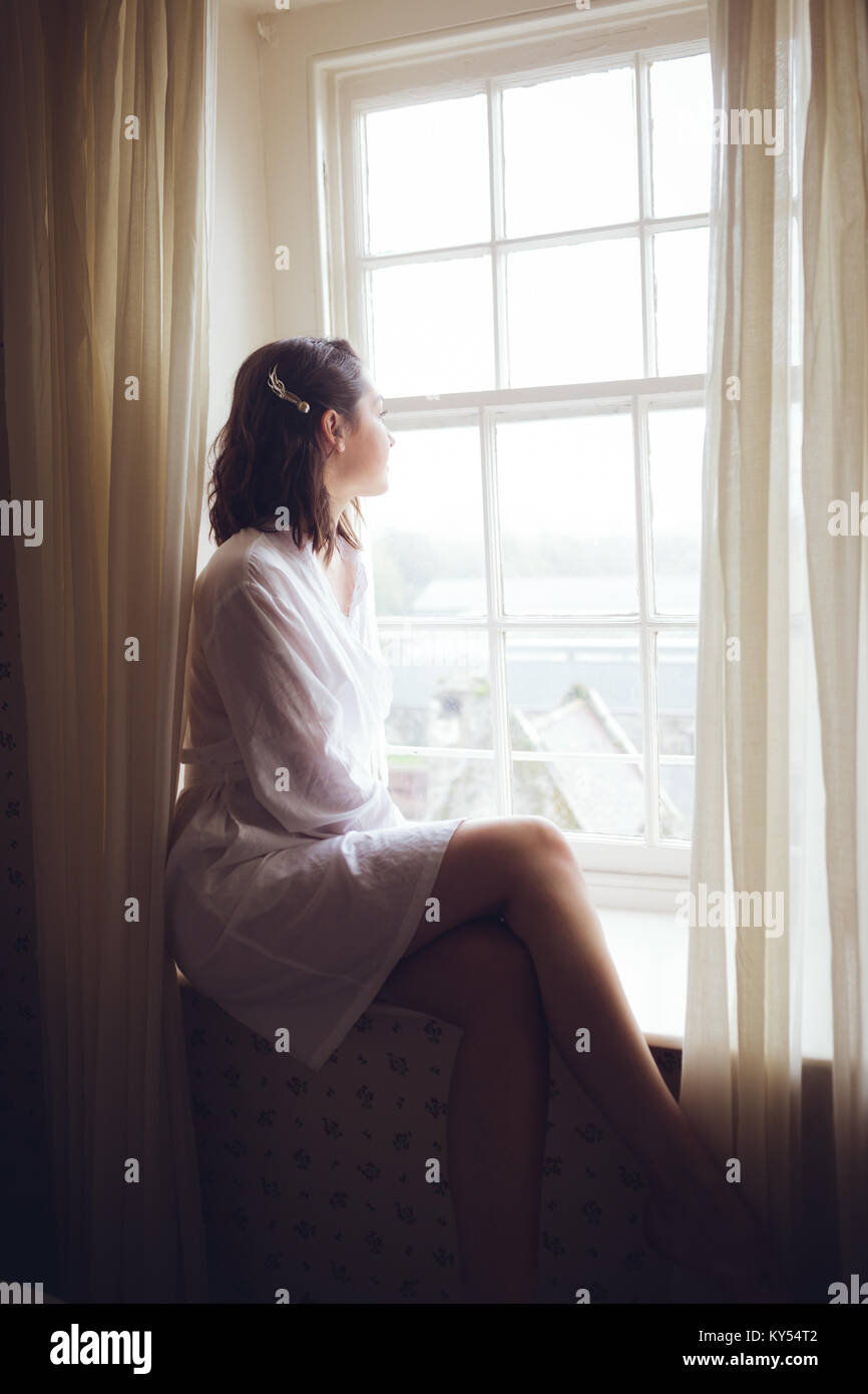 Thoughtful woman looking out of the window Stock Photo - Alamy