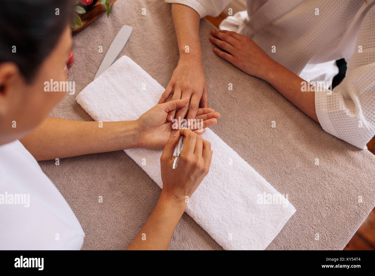 Top view of female hands in salon receiving a manicure and nail care ...