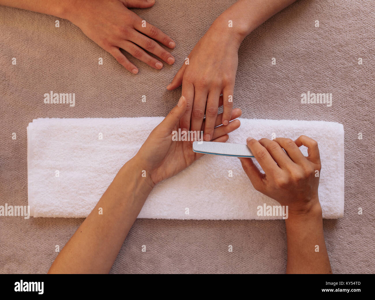 Top view of woman hands in nail salon receiving a manicure by ...