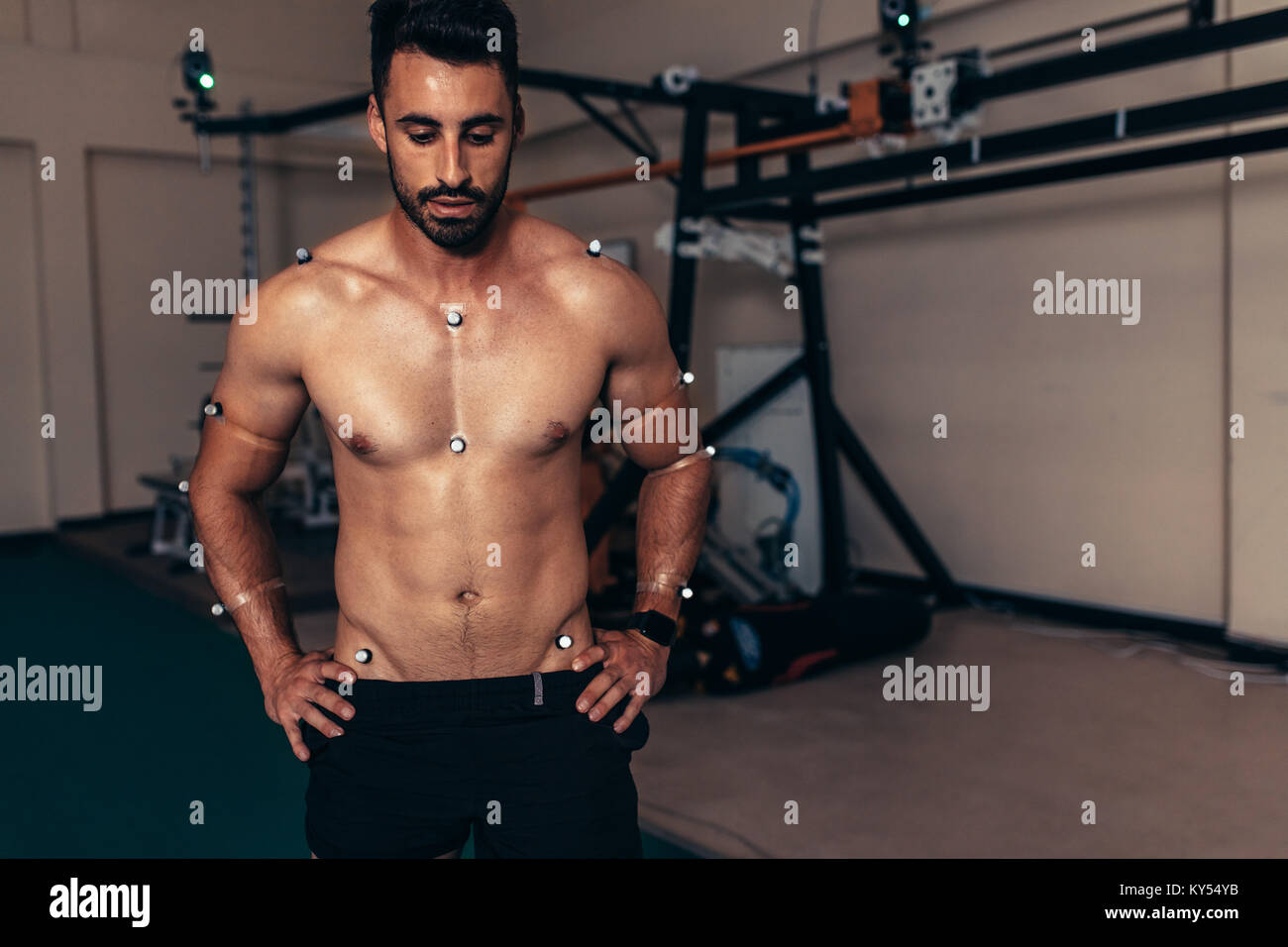 Muscular young woman with motion capture sensors on body in sports lab ...