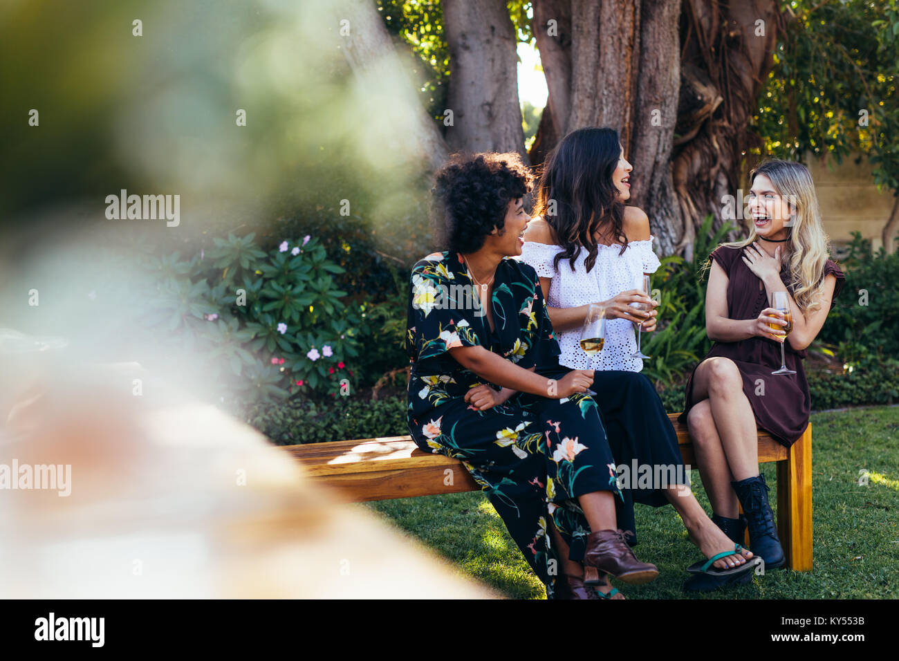 Cheerful young women hanging out with drinks. Group of female friends ...