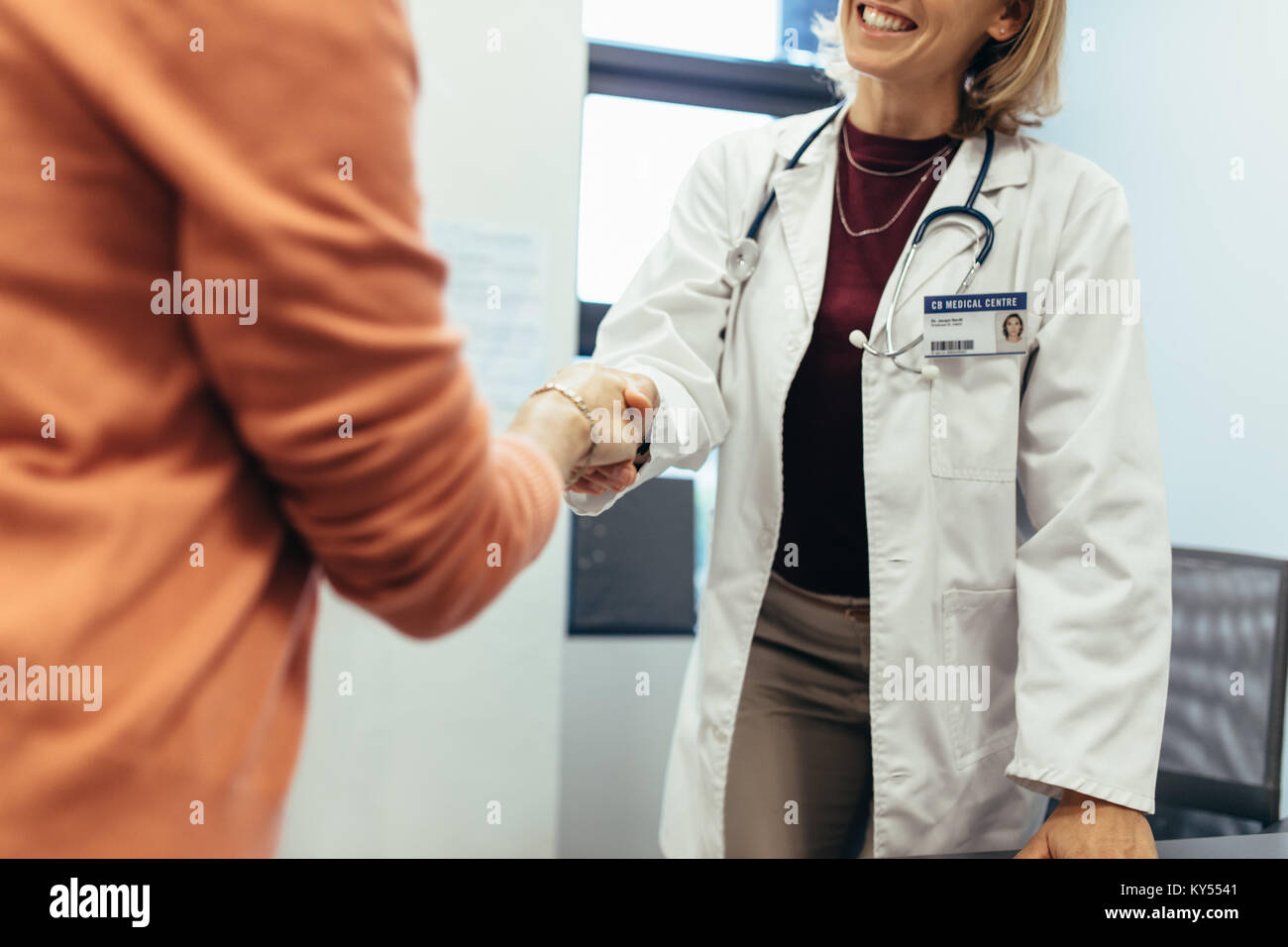 Friendly medical professional shaking hands with woman. Doctor and ...